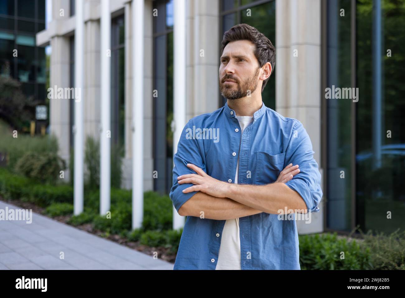 Mature bearded businessman in casual clothing confidently standing with ...