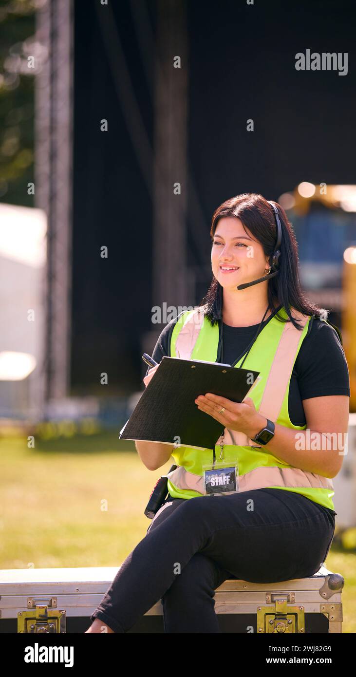 Female Production Worker Setting Up Outdoor Stage For Music Festival Or ...