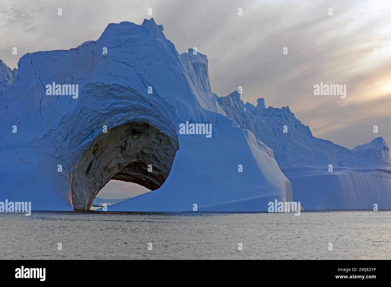 Iceberg with cave, midnight sun, Ilulissat, Disko Bay, Denmark ...