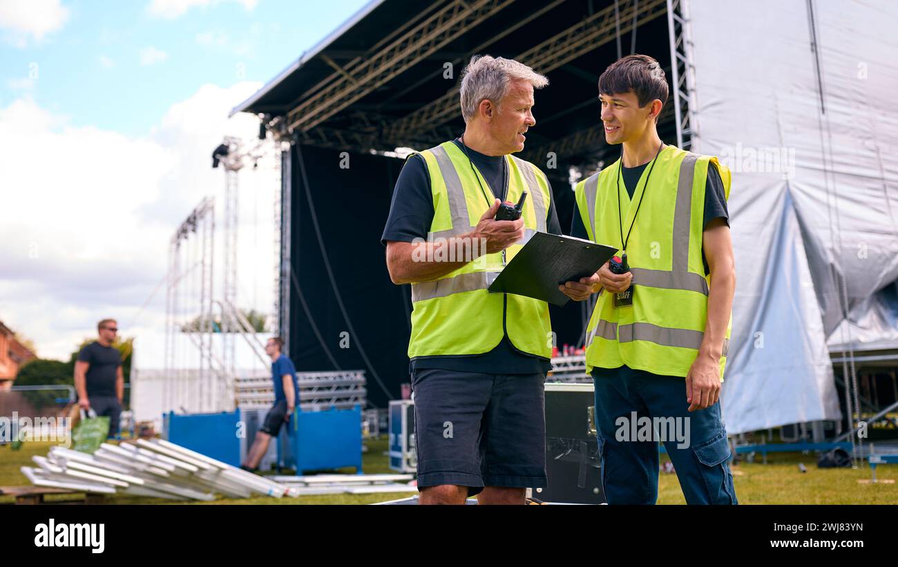Male Production Team With Flight Cases Setting Up Outdoor Stage For ...