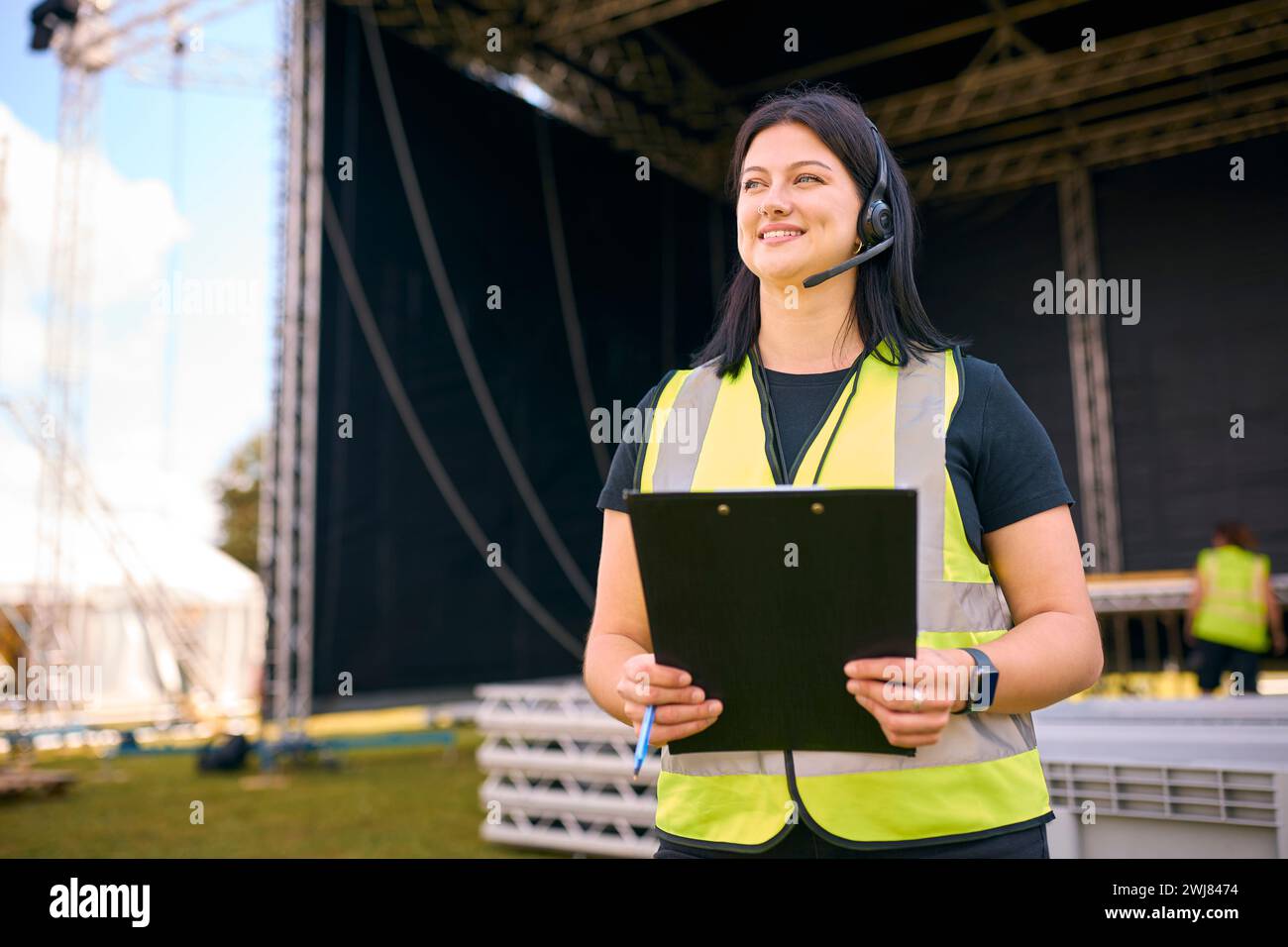 Portrait Of Female Production Worker Setting Up Outdoor Stage For Music ...