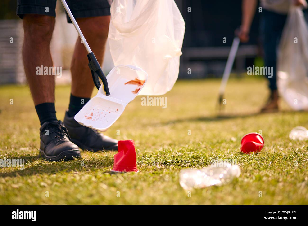 Close Up Of Volunteers Picking Up Litter After Outdoor Event Like ...
