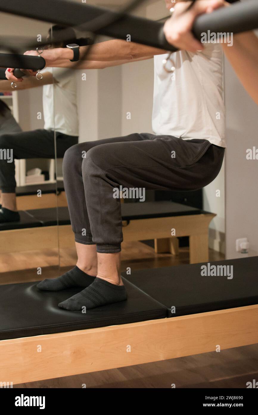 Training session standing on reformer bed. Caucasian woman Stock Photo ...