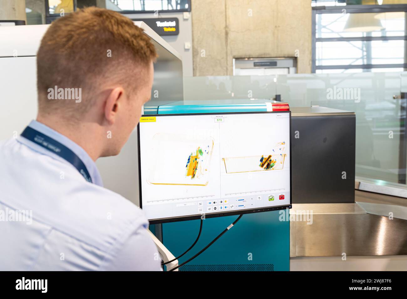 Airport security baggage screening. Security man looking at monitor ...