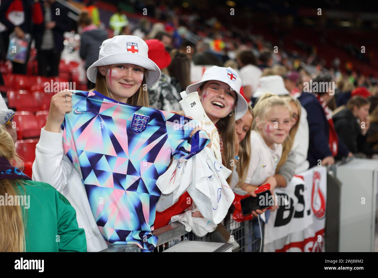 Young female fans in England hats and facepaint smile and hold shirt ...