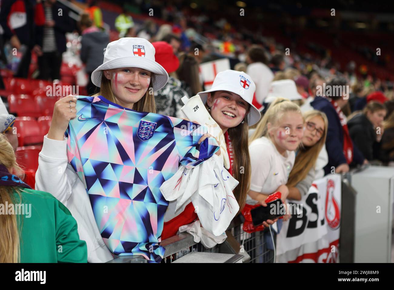 Young female fans in England hats and facepaint smile and hold shirt ...