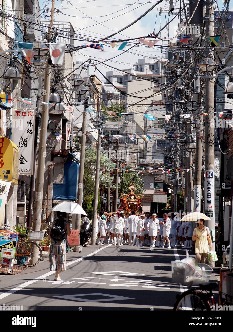Daily life in Japan A scene of men in white costumes carrying a mikoshi ...