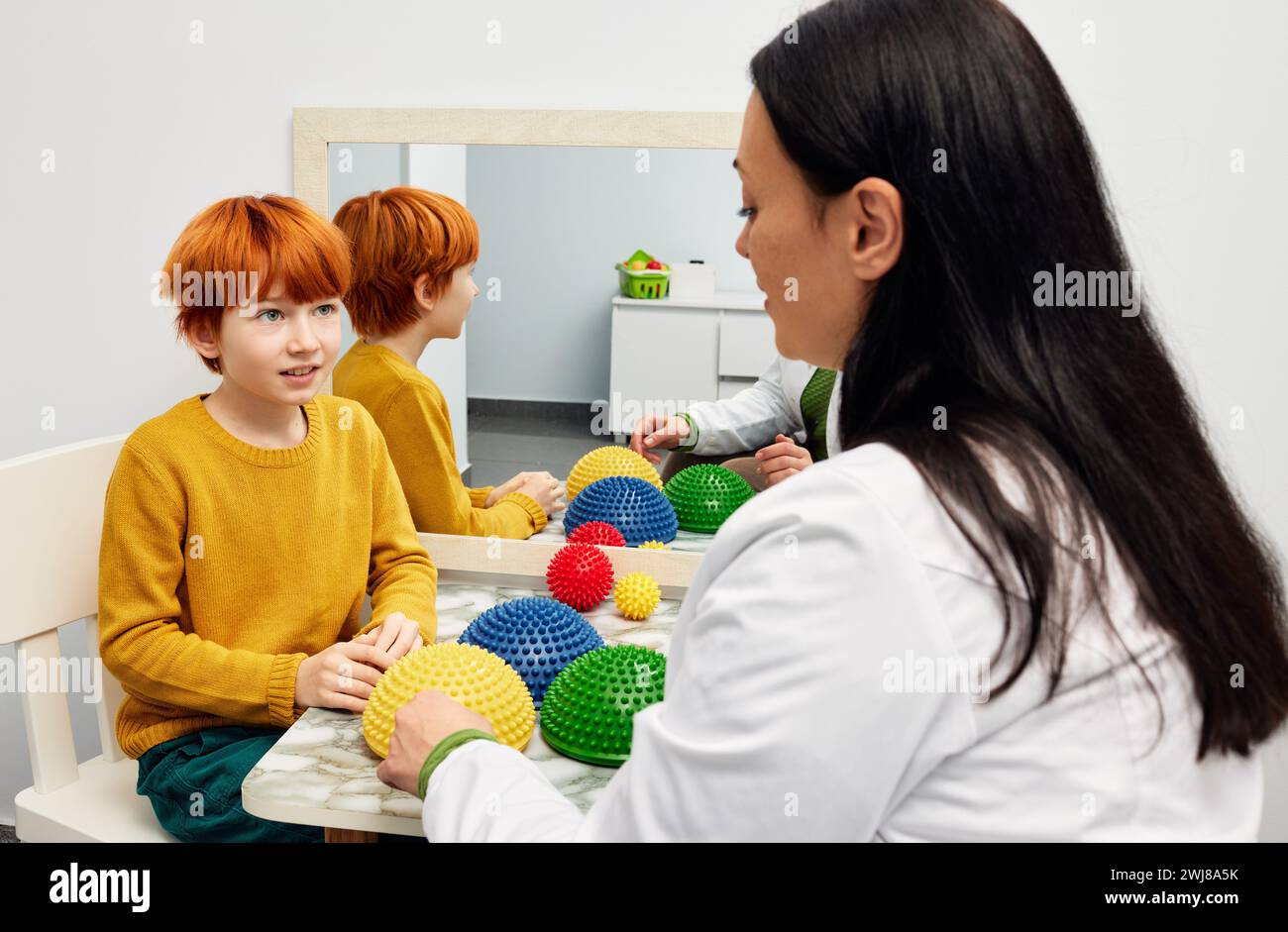 Sensory integration therapy. Boy with autism spectrum disorder working with therapist using ...