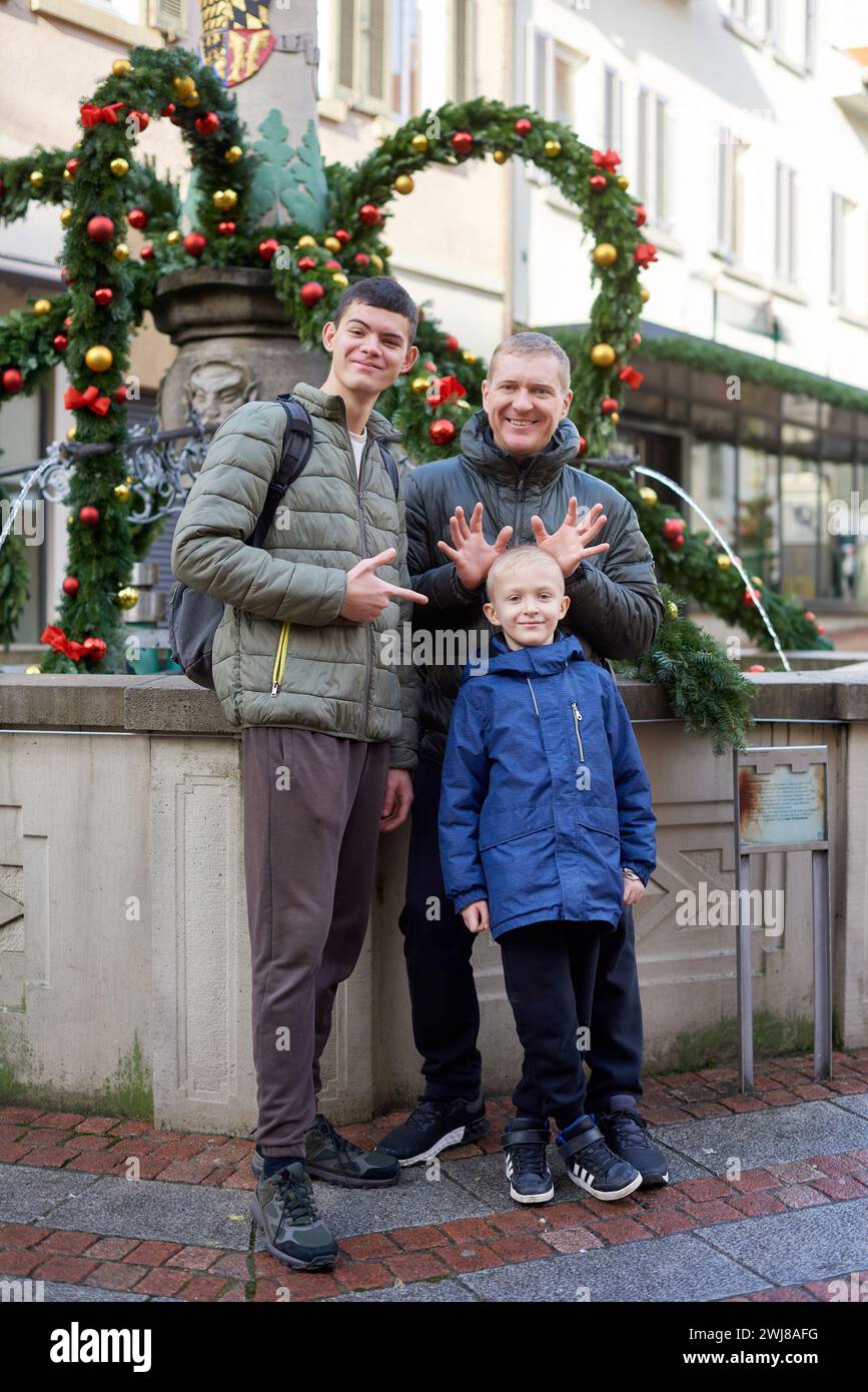Joyful Family Portrait: Father and Two Sons by Festive Vintage Fountain ...