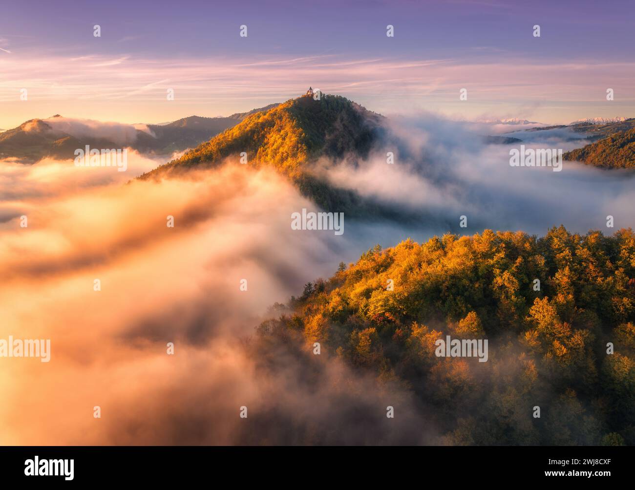 Aerial view of mountain peak in low clouds at sunrise in autumn Stock ...