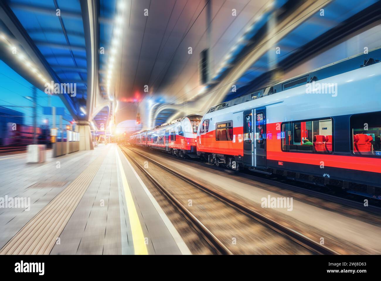High speed train in motion on the railway station at night Stock Photo ...