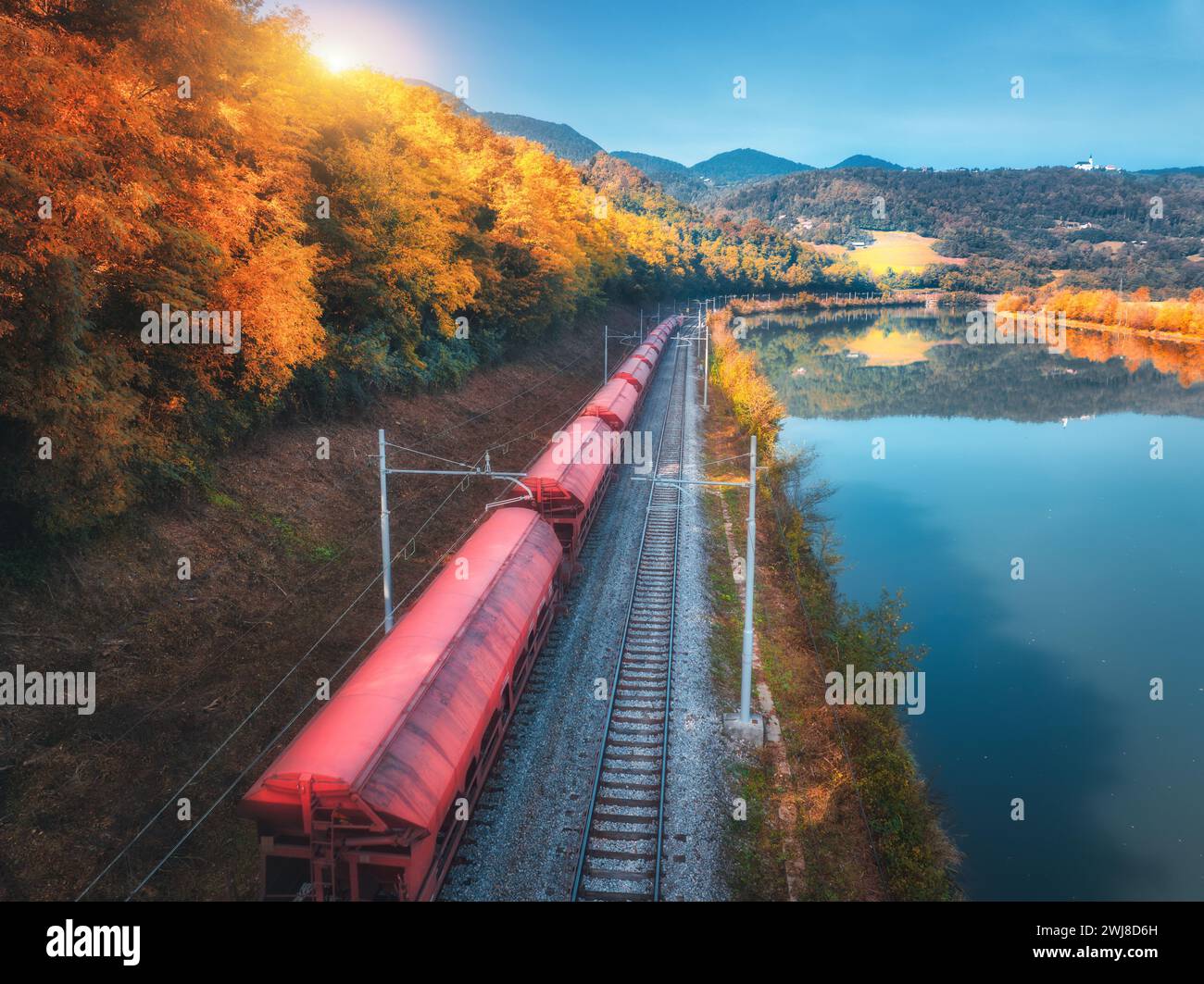 Aerial view of freight train moving near river in mountains Stock Photo ...