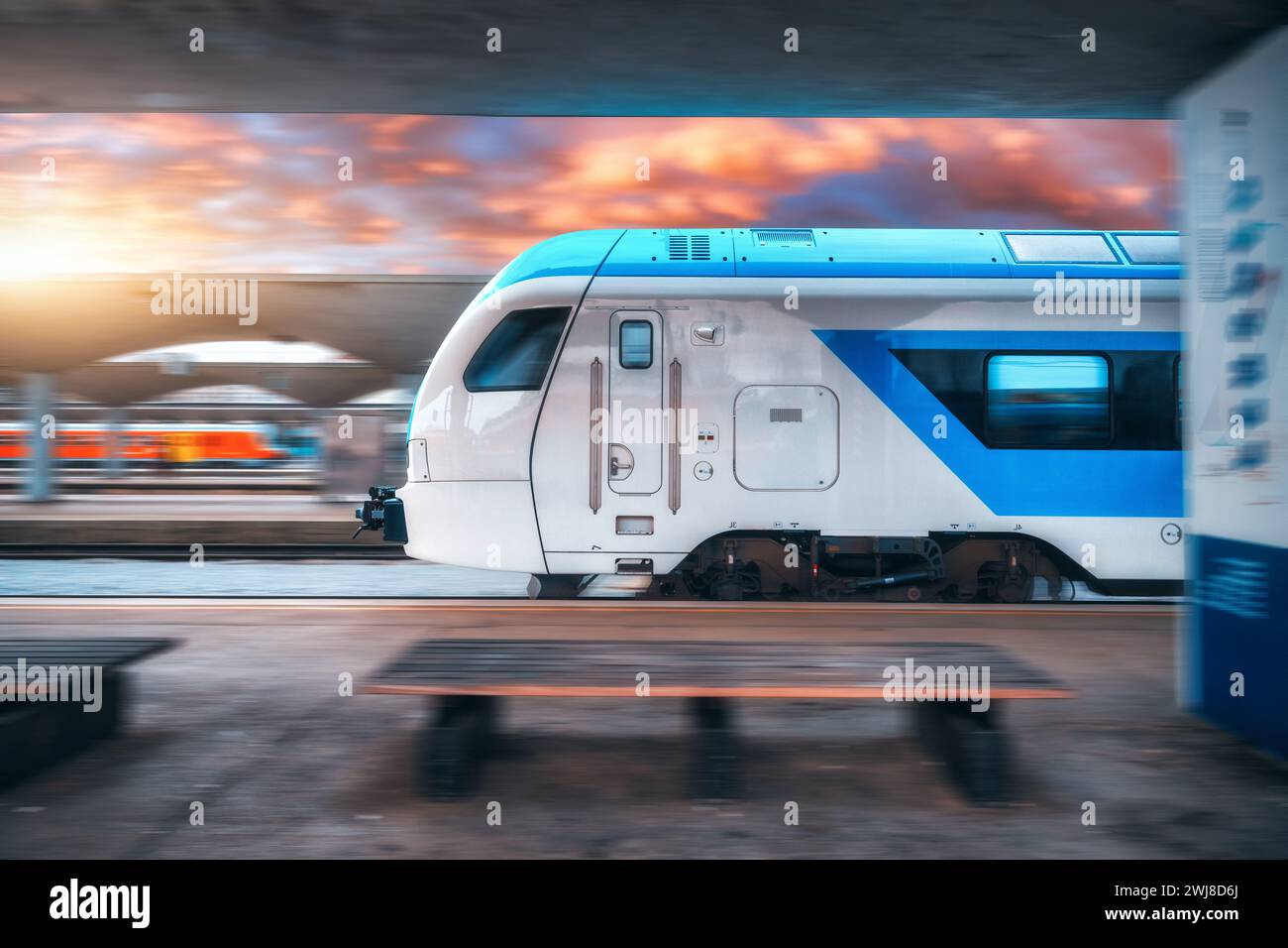 Blue high speed train in motion on the railway station at sunset Stock ...