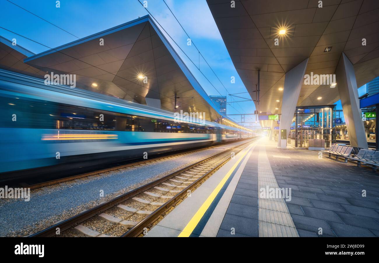 High speed train in motion on the railway station at night Stock Photo ...