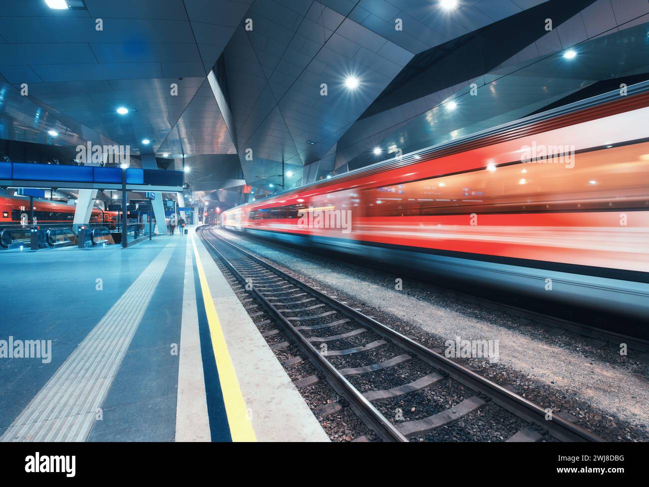 High speed train in motion on the railway station at night Stock Photo ...