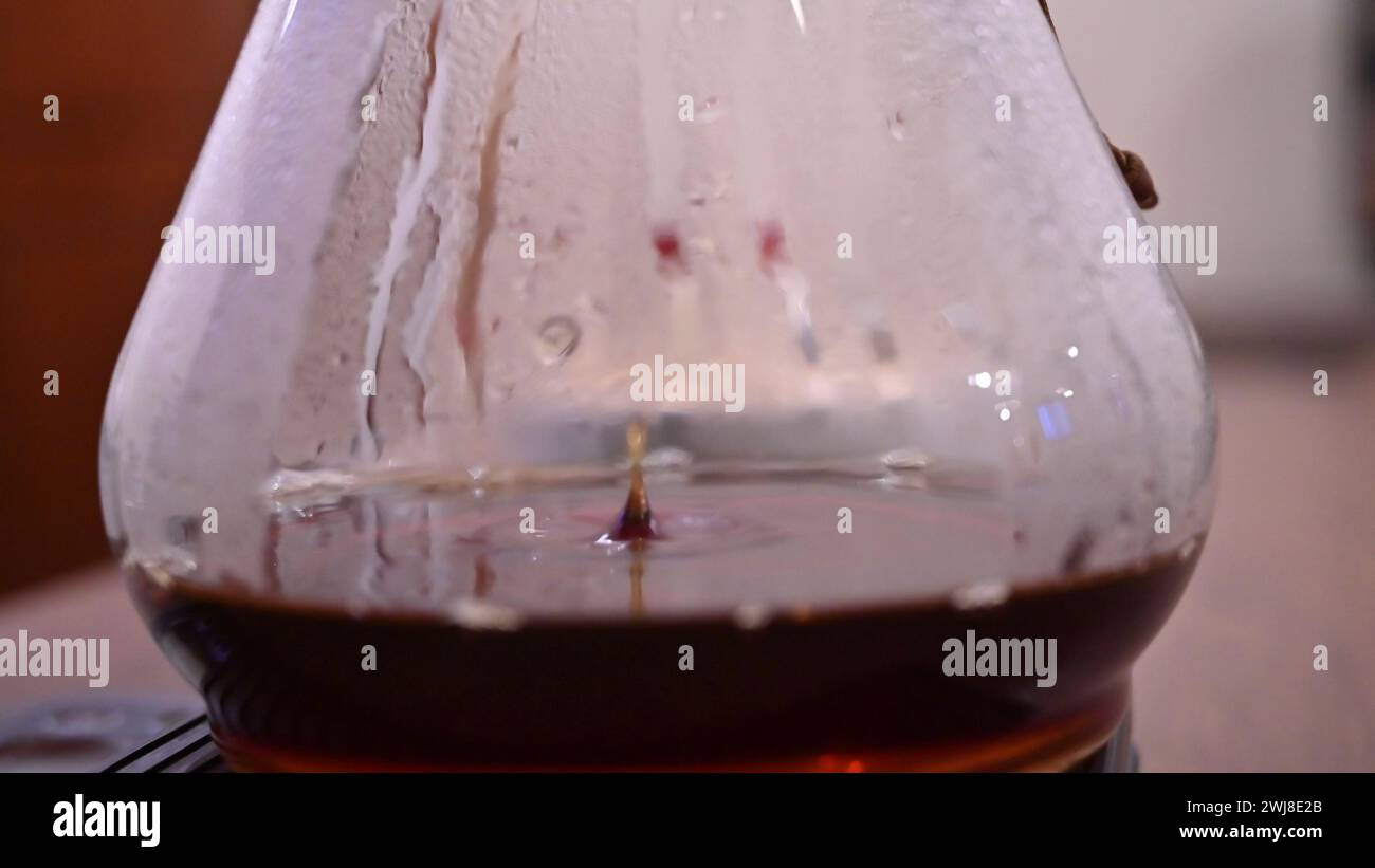 Barista pours water into the filter with coffee, brewing coffee ...