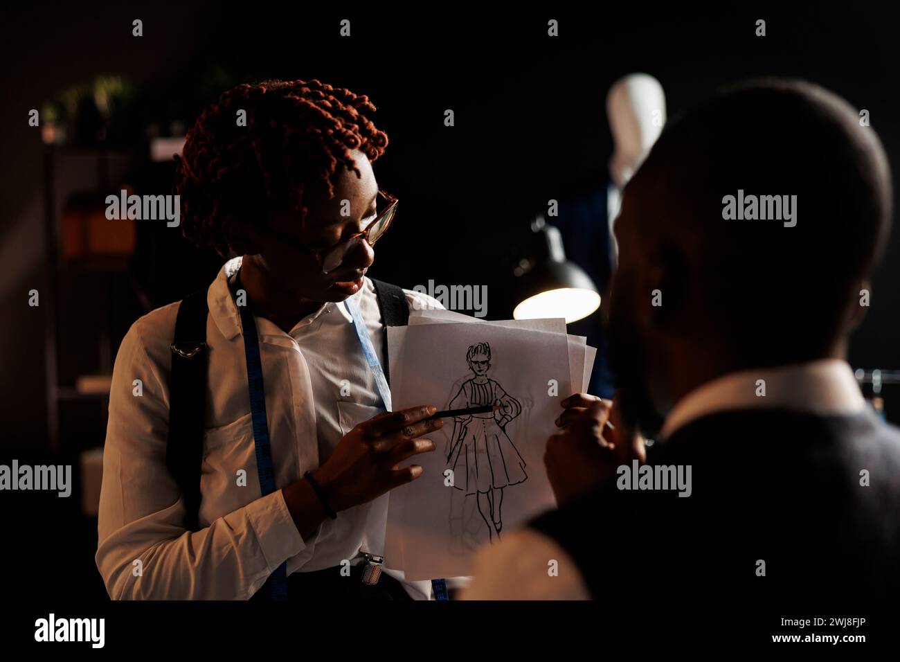 Experienced fashion designer showing couturier sketch drawing of ...