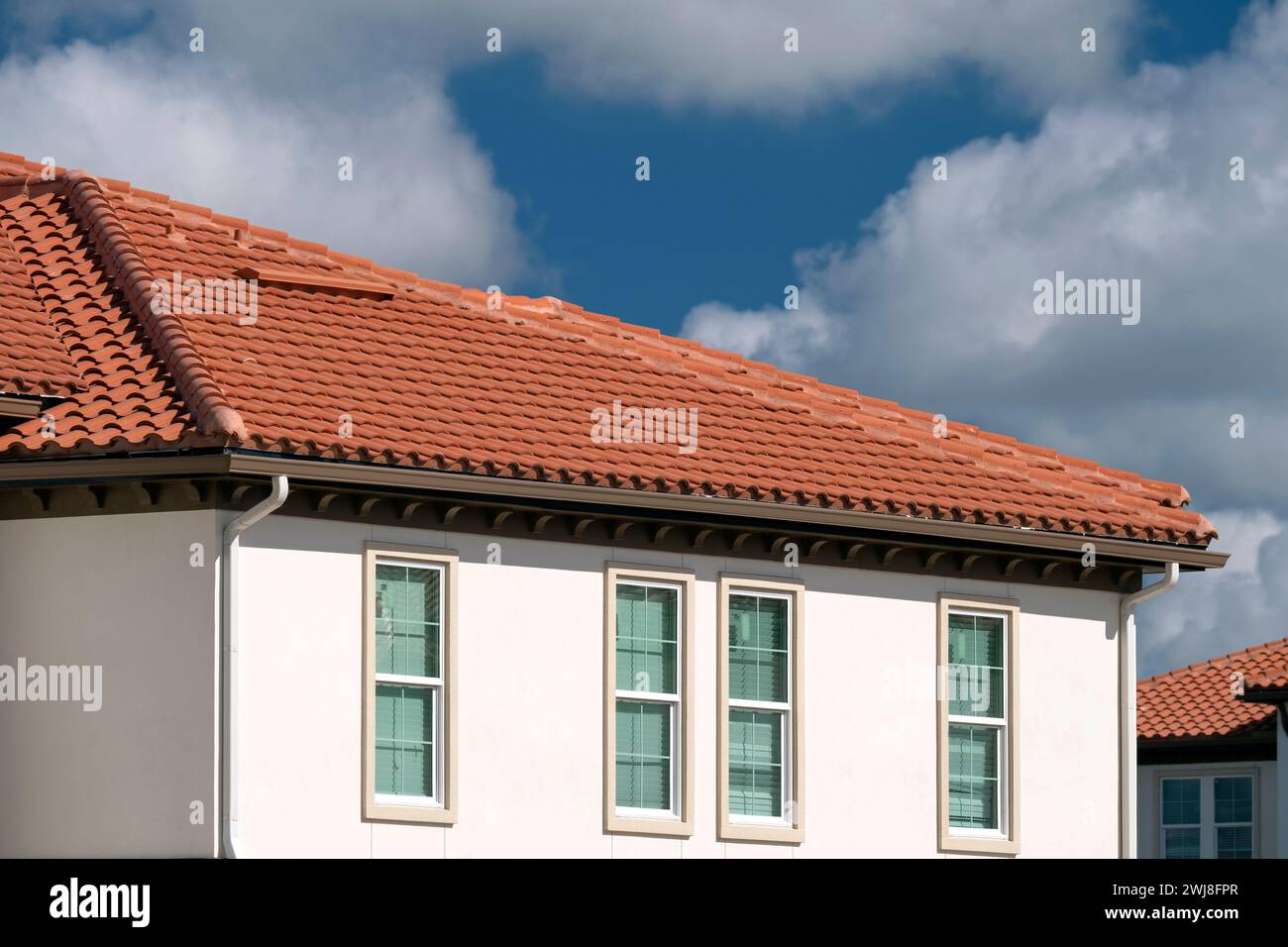 Overlapping rows of yellow ceramic roofing tiles covering residential ...