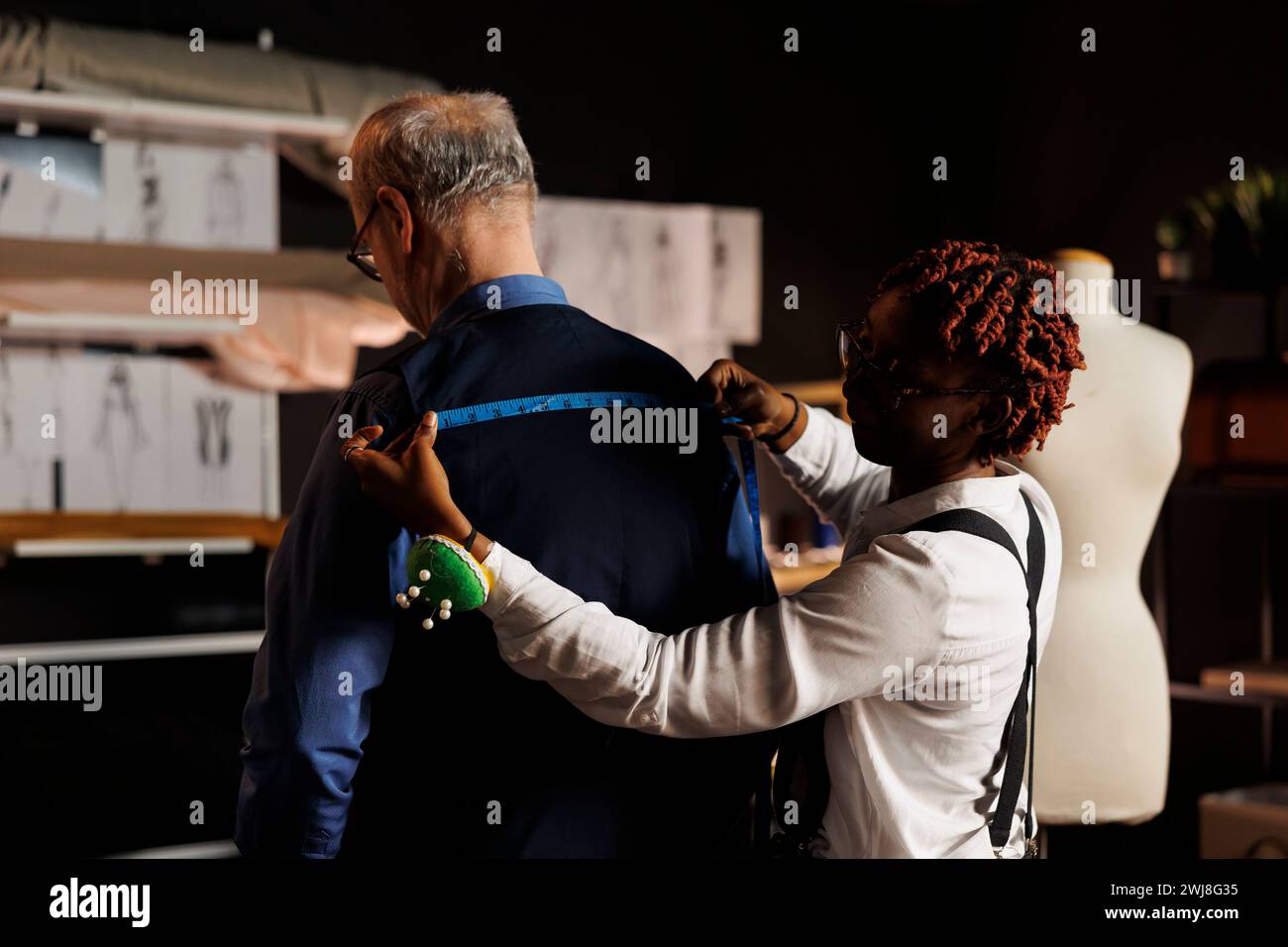 Expert seamstress sizing up stylish client proportions for upcoming ...