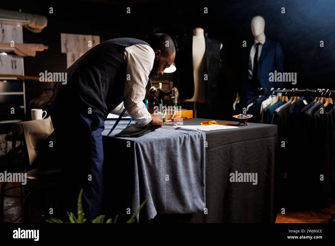 Meticulous suitmaker focused on perfecting client comissioned exquisite ...