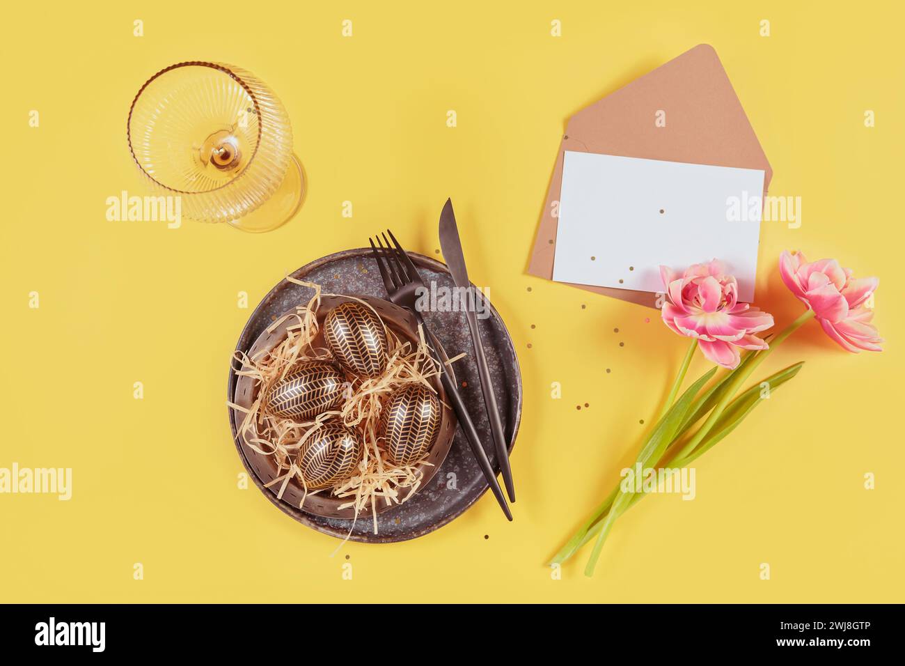 Table place setting with empty greeting or invitation card and Easter ...