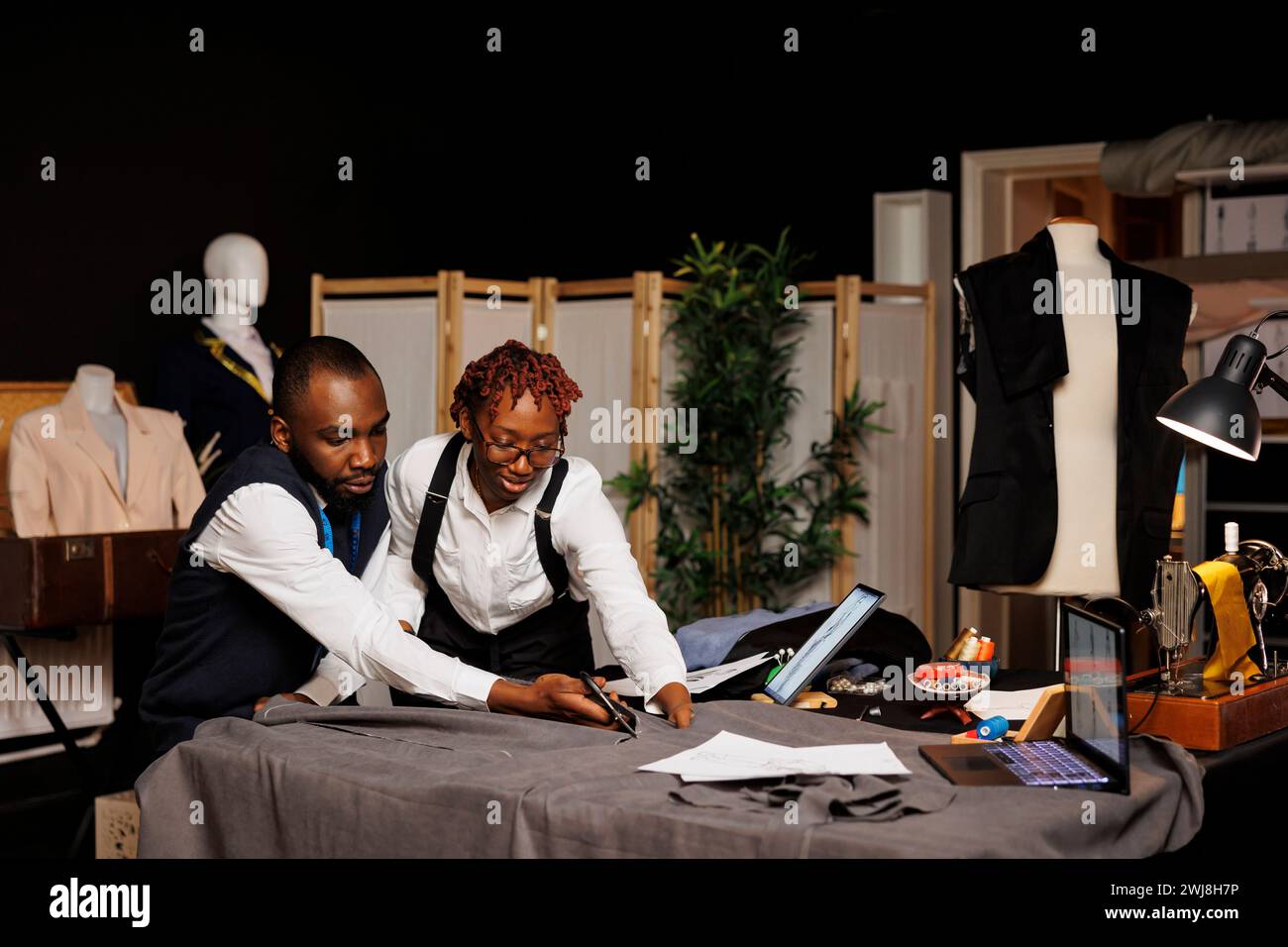 High end manufacturing suitmakers cutting textile material with ...