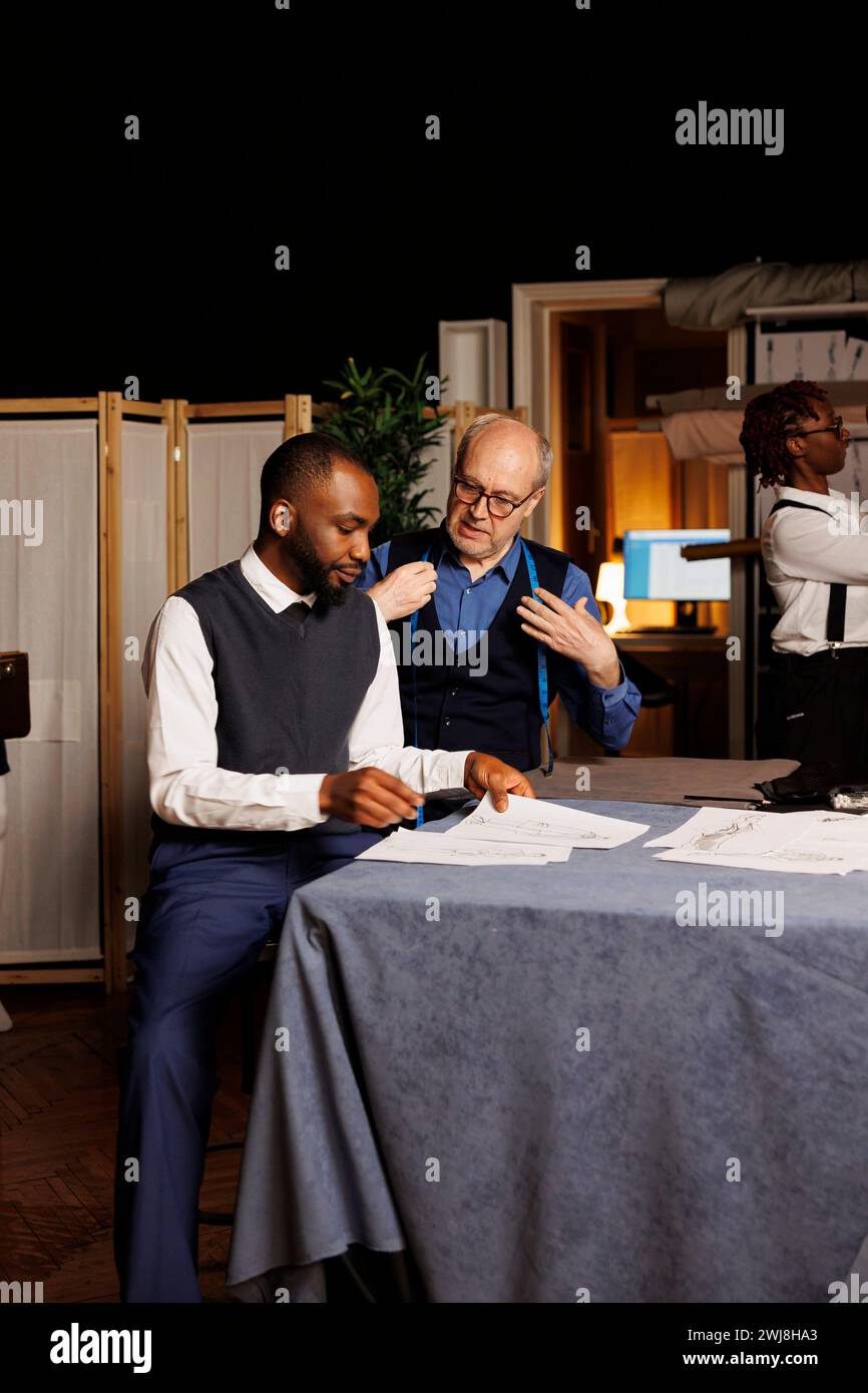 Stylish customer discussing best suit customizations options with ...