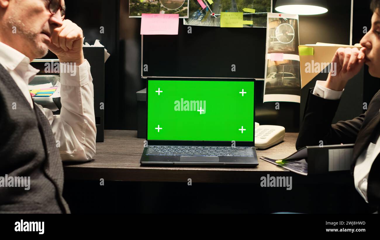 Inspectors review greenscreen on laptop, working together in incident ...