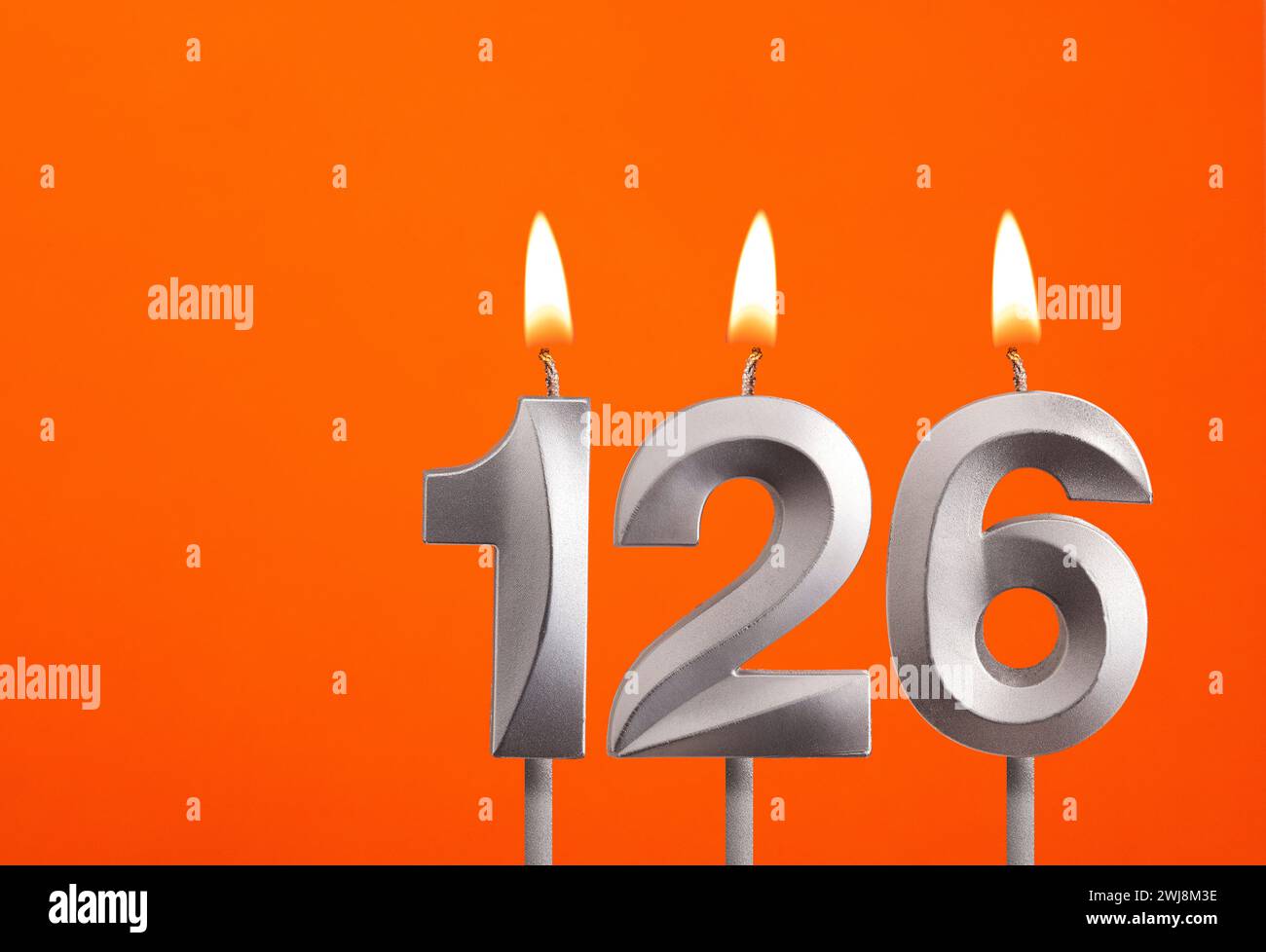 Candle number 126 - Birthday in orange background Stock Photo - Alamy