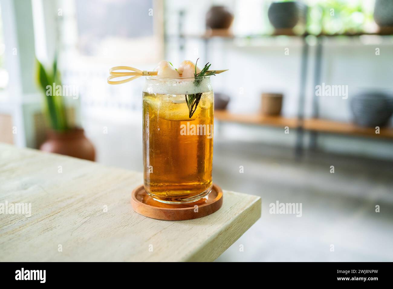 Fresh cold drink of lychee tea on a table with an elegant cafe in the ...