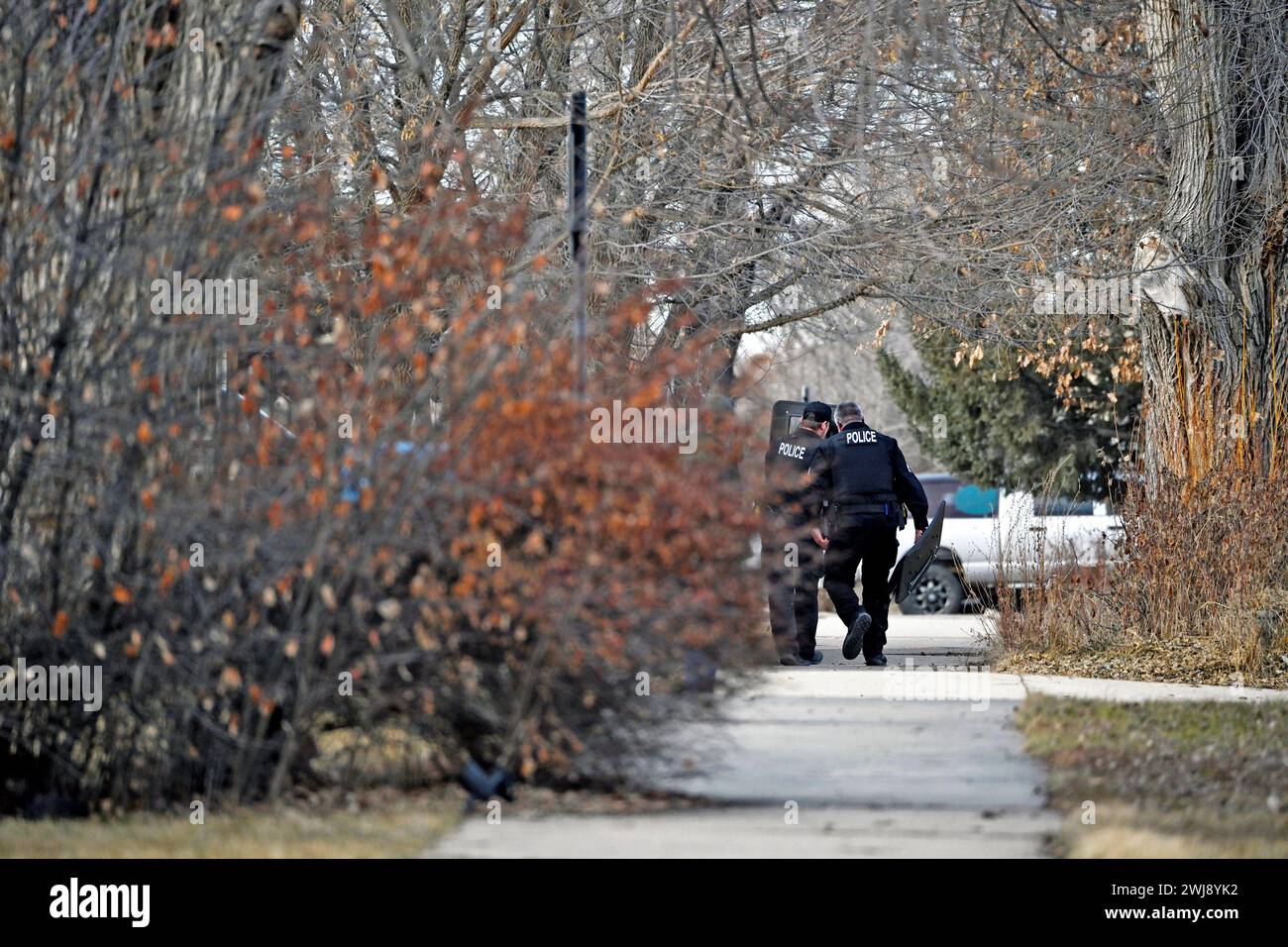 Two Gillette Police officers carry shields near a residence where a ...
