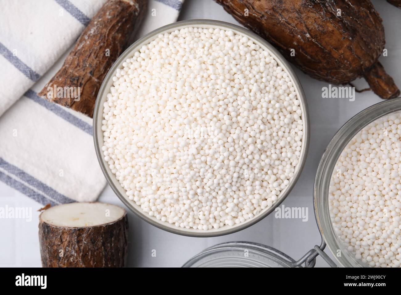 Tapioca pearls and cassava roots on white tiled table, flat lay Stock ...