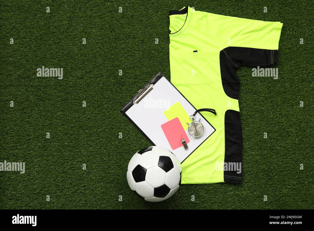 Uniform, soccer ball and other referee equipment on green grass, top ...
