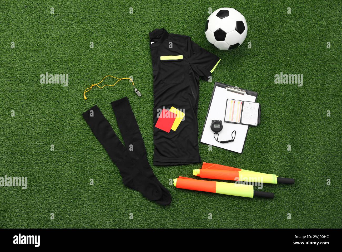 Uniform, soccer ball and other referee equipment on green grass, flat ...