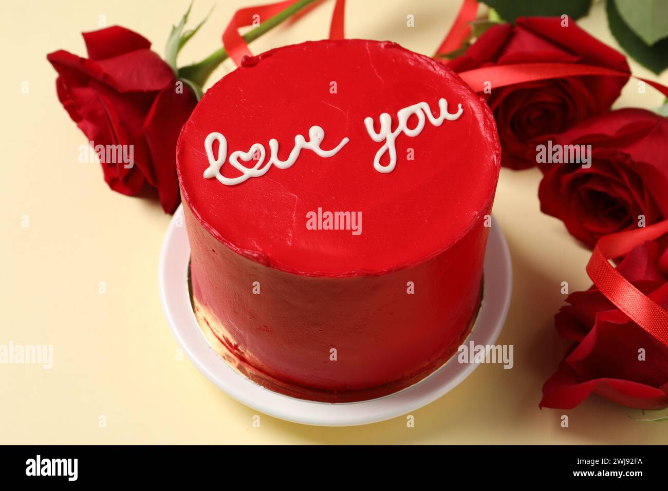 Bento cake with text Love You and red roses on beige table, closeup. St ...