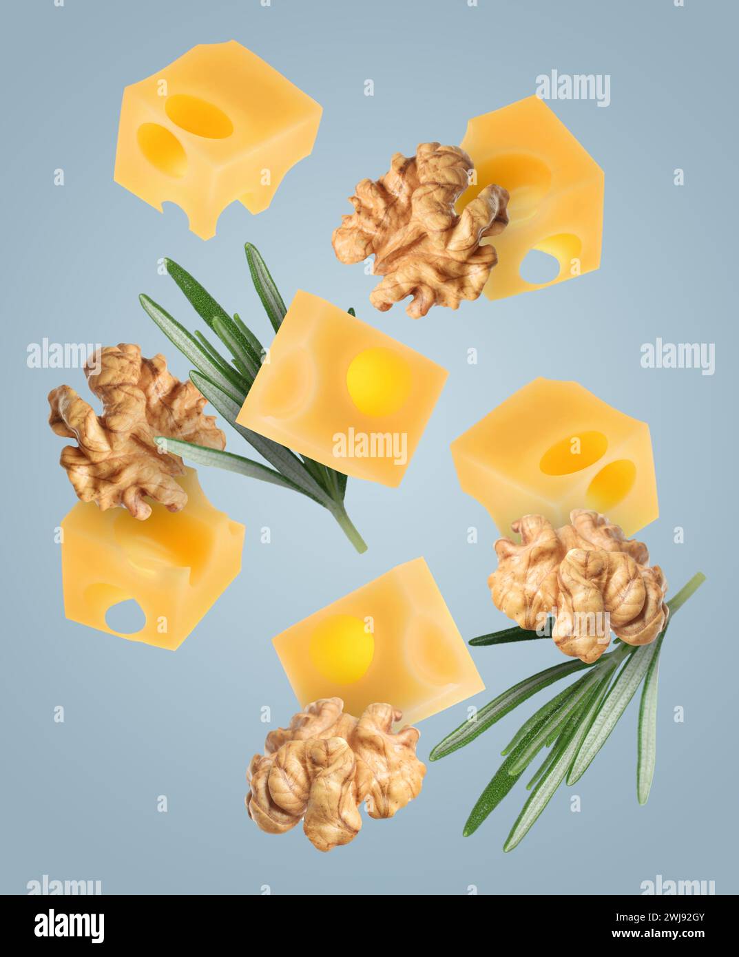 Cheese, walnuts and rosemary flying on light blue background Stock ...