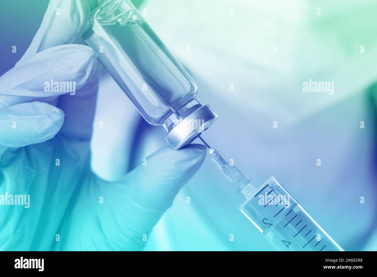 Doctor filling syringe with medication from vial, closeup. Color toned ...