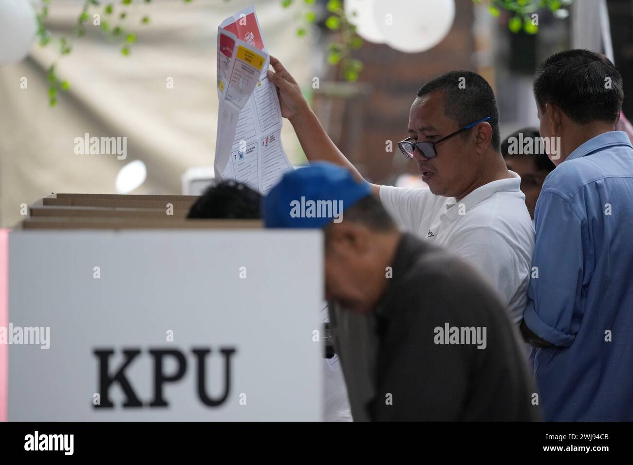 People vote at a polling station during the election in Jakarta ...