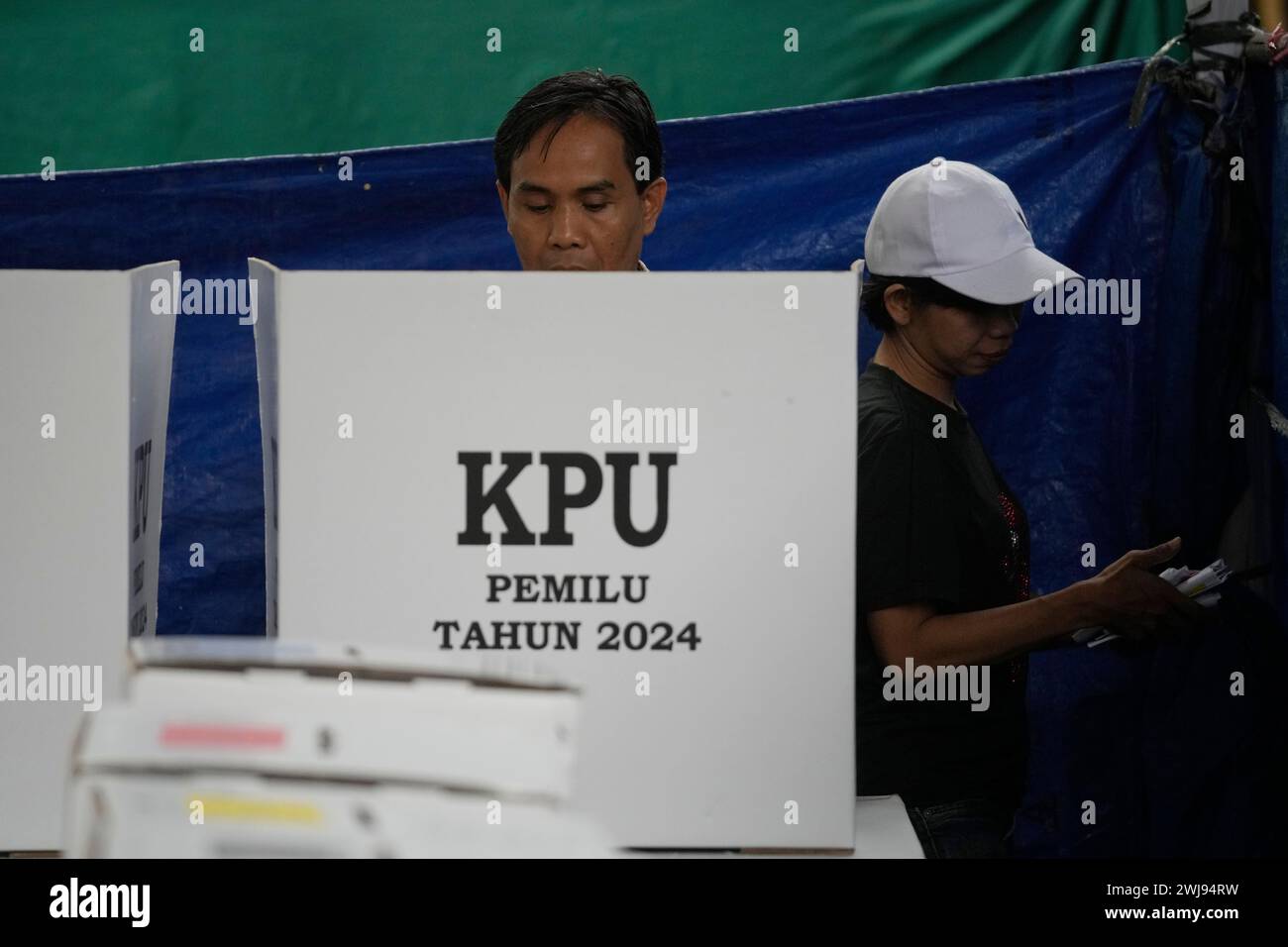 People vote at a polling station during the election in Jakarta ...