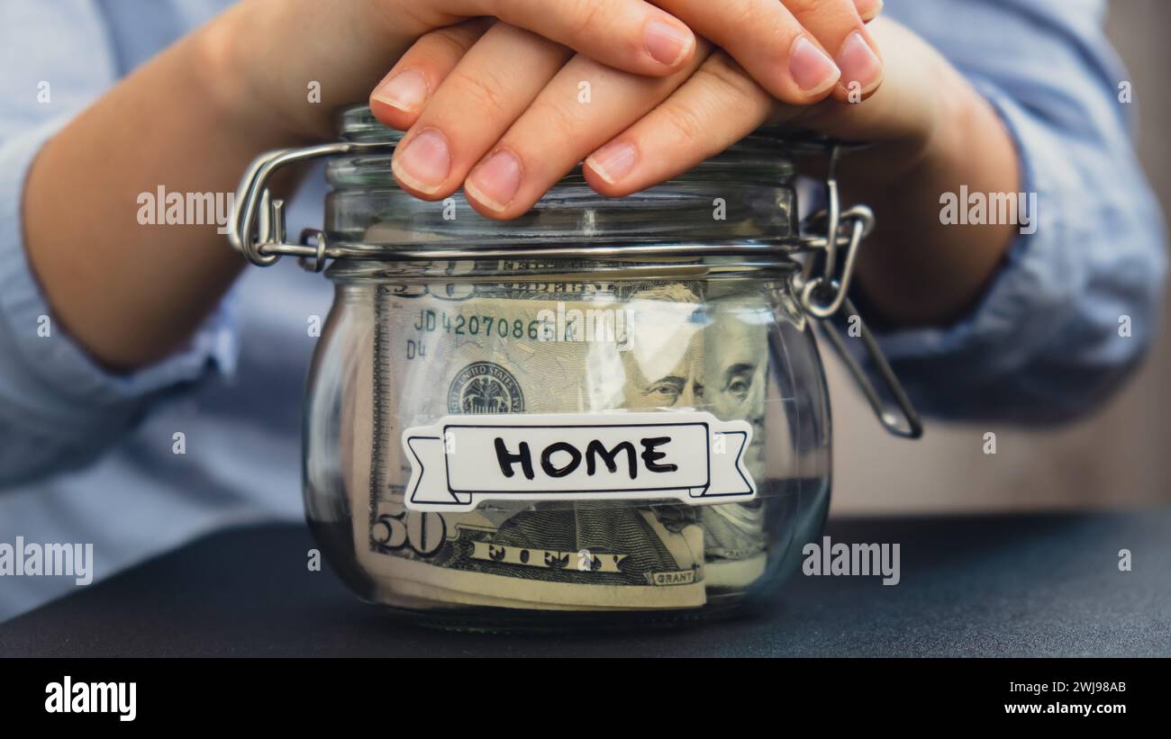 Female hands holding Glass jar full of American currency dollars cash ...