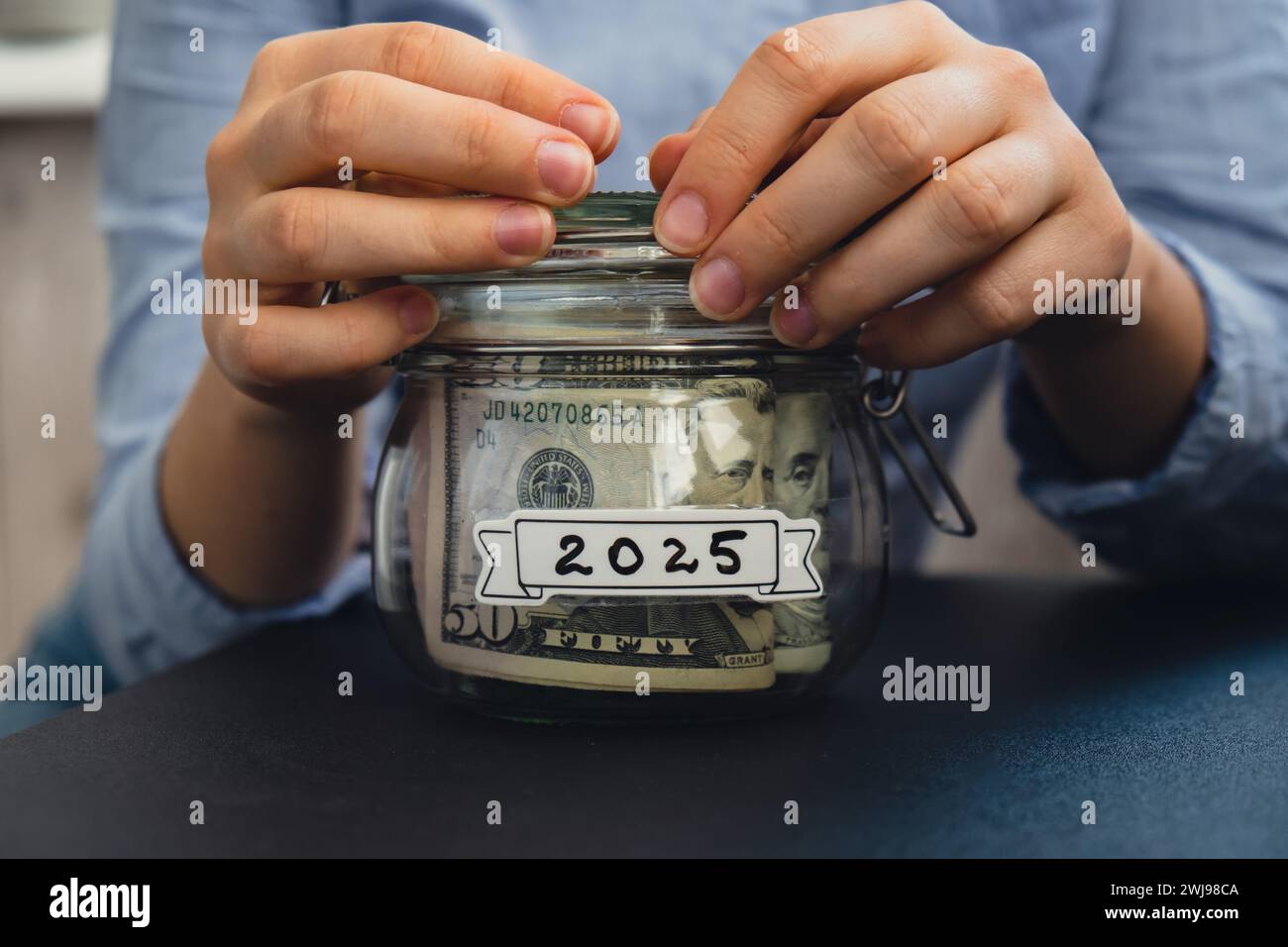 Female hands holding Glass jar full of American currency dollars cash ...