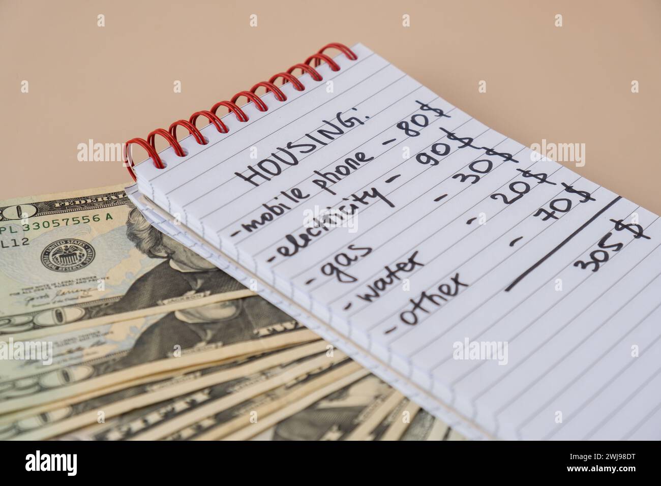 Dollar cash money with notebook handwritten housing expenses. Counting ...