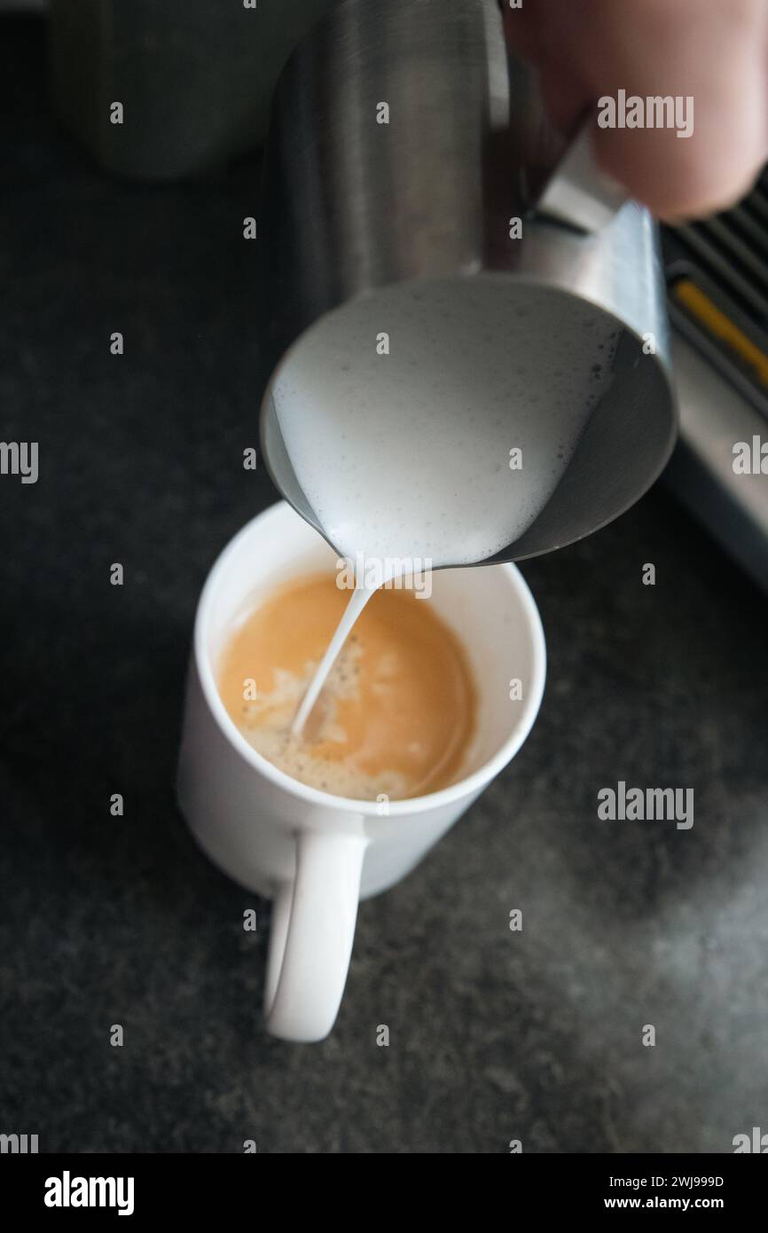 Pouring steamed milk for a latte, making coffee, barista Stock Photo ...