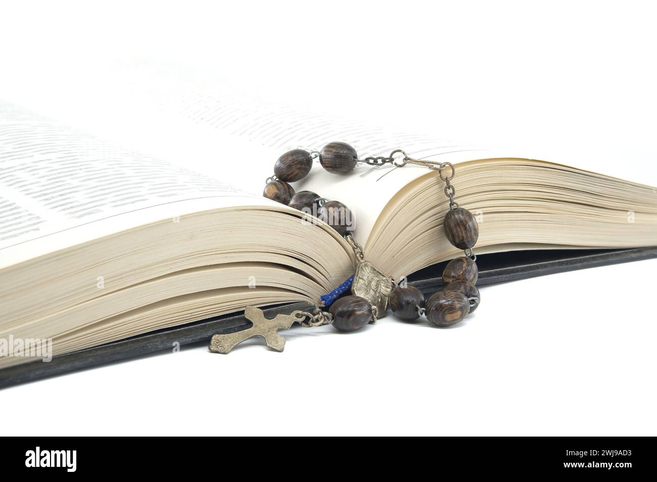 Open book is placed against a white background, with a rosary carefully ...