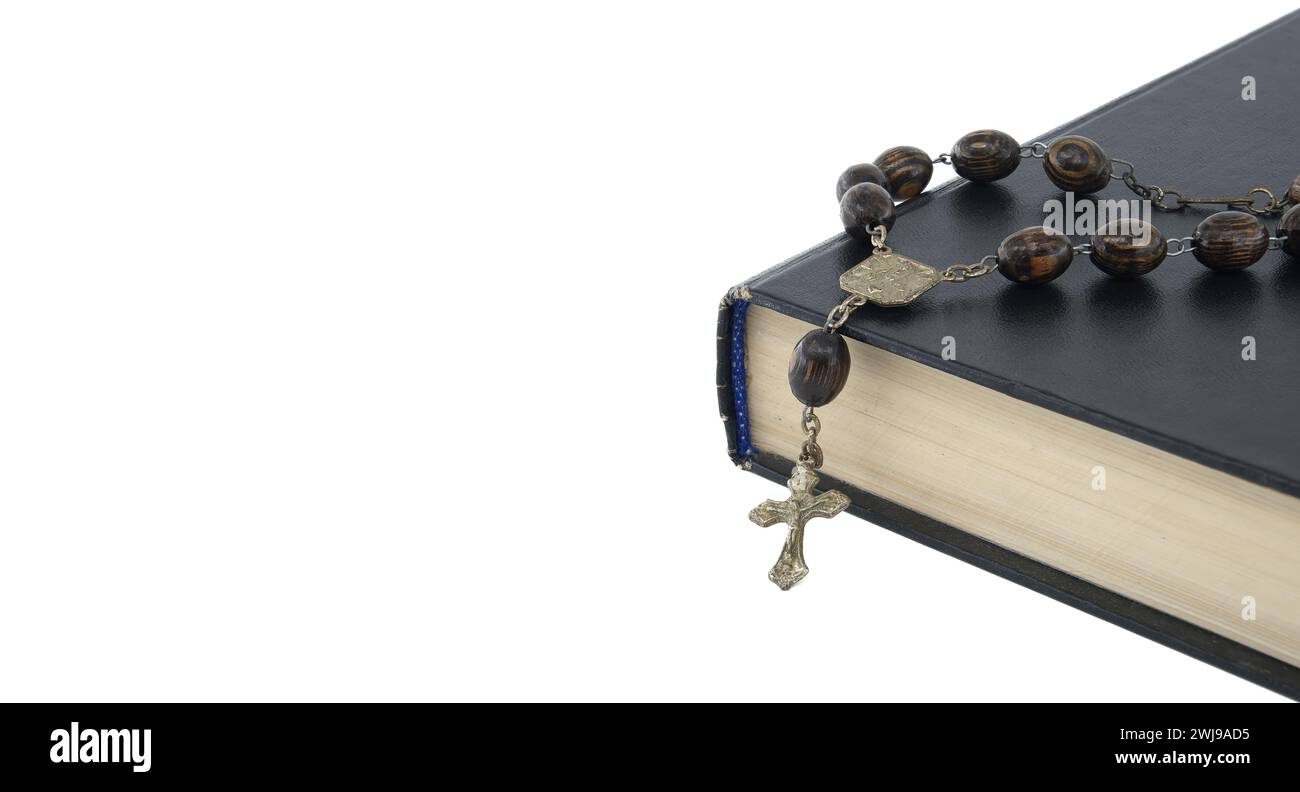 Rosary with wooden beads and a crucifix placed on top of a black Bible ...