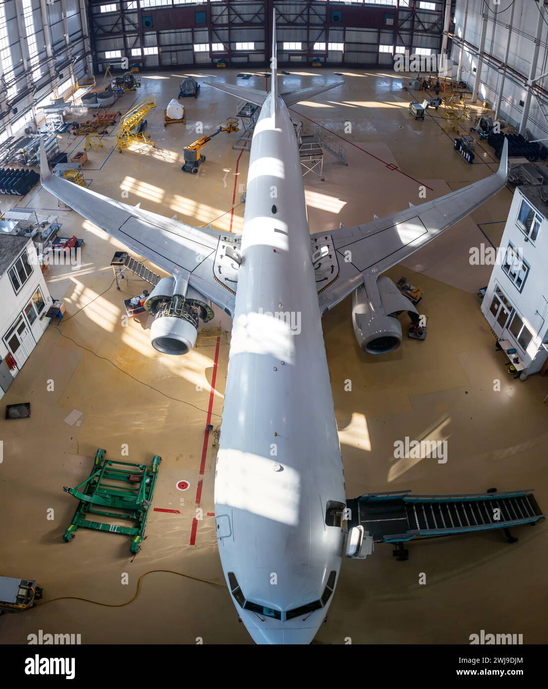 Top view of a white passenger jetliner in the aviation hangar. Airliner ...