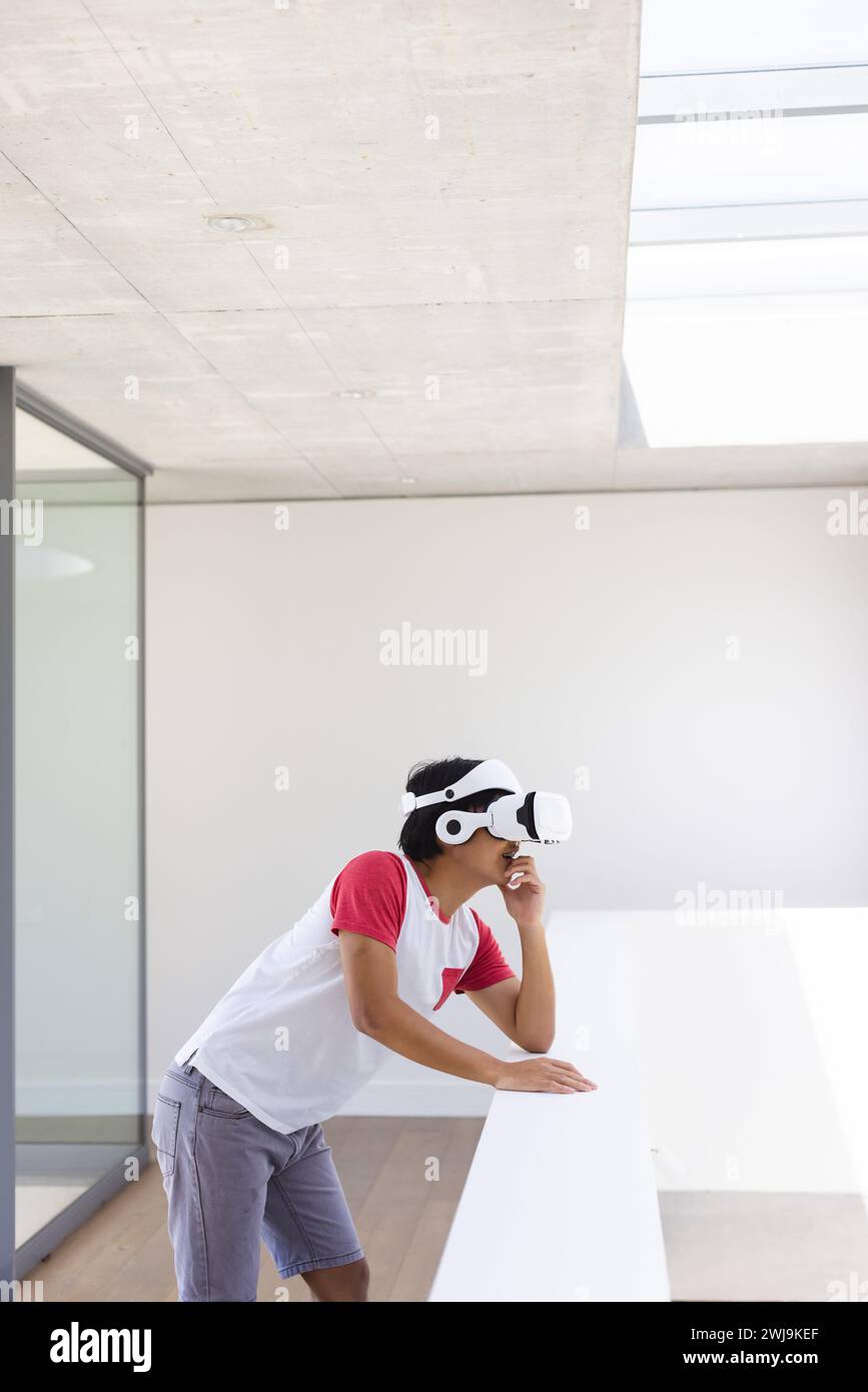 Teenage Asian boy explores virtual reality indoors, with copy space ...
