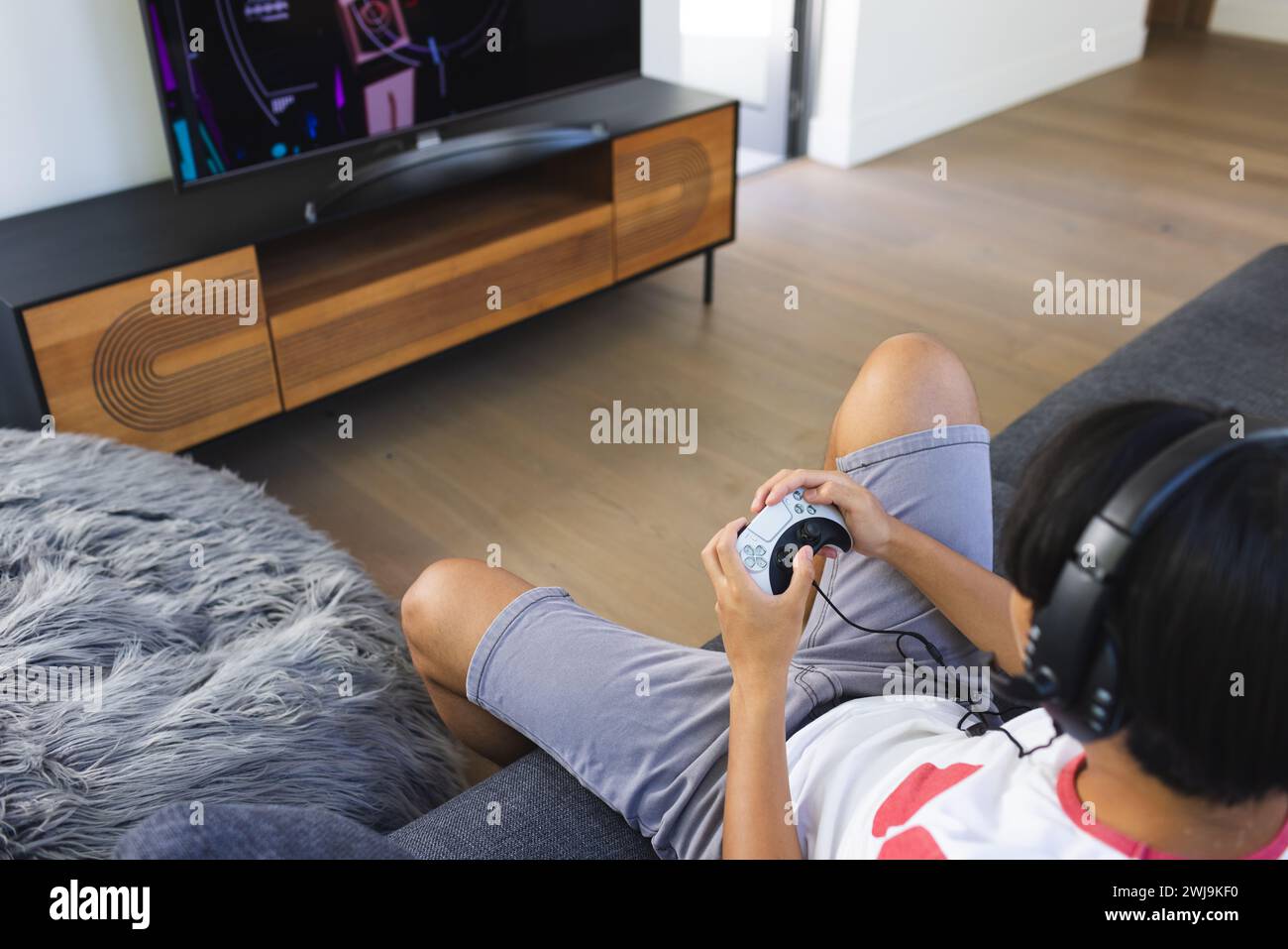 Teenage Asian boy enjoys gaming at home, with copy space Stock Photo ...