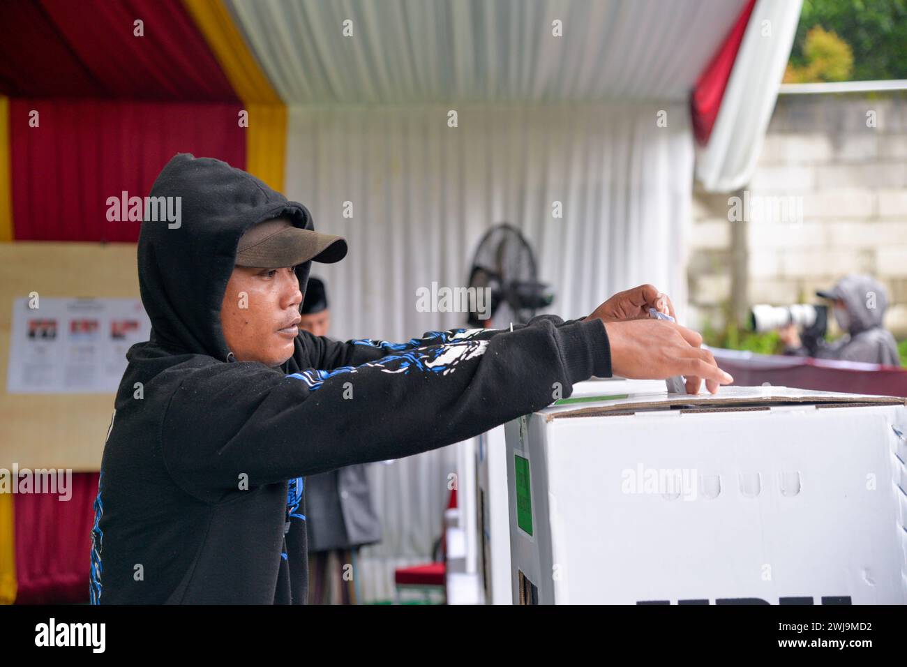 Bogor, Indonesia. 14th Feb, 2024. A voter casts his ballot at the No ...