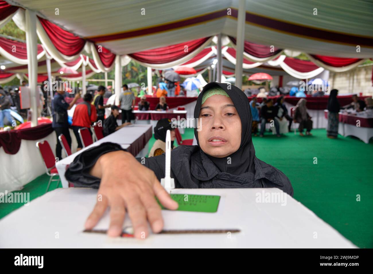Bogor, Indonesia. 14th Feb, 2024. A voter casts her ballot at the No ...